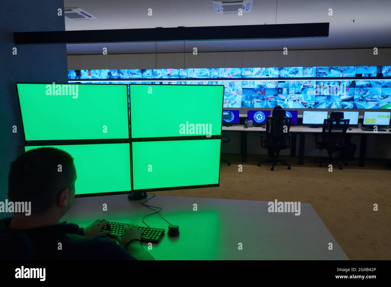 Male security operator working in a data system control room offices ...