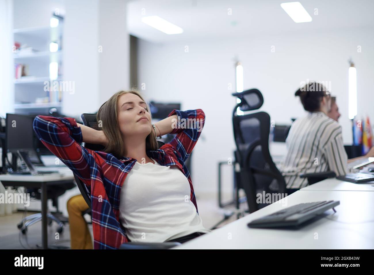casual business woman taking a break while working on desktop computer ...