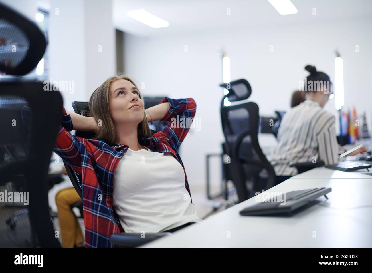 casual business woman taking a break while working on desktop computer ...