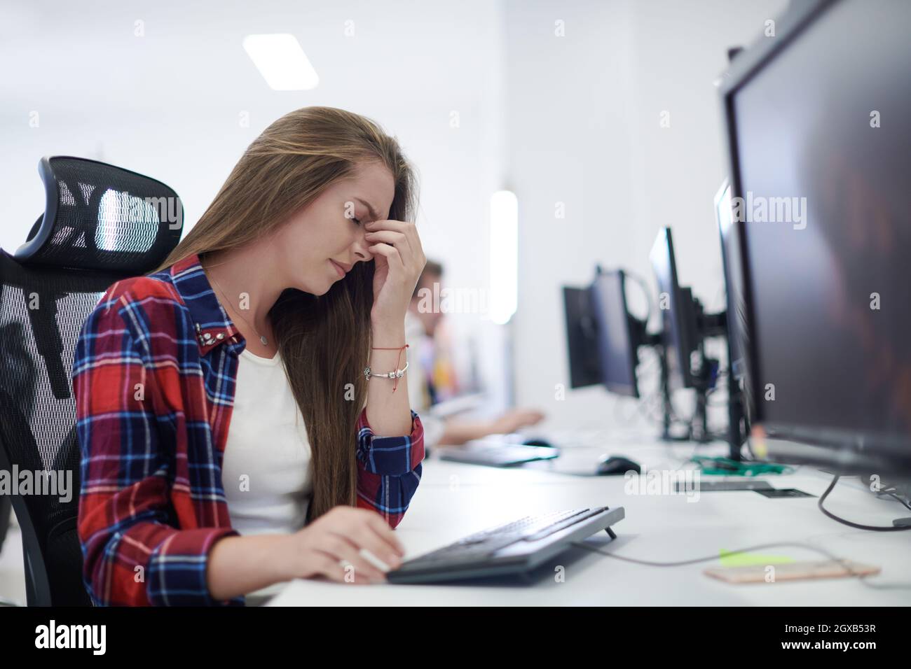 tired casual business woman taking a break while working on desktop ...