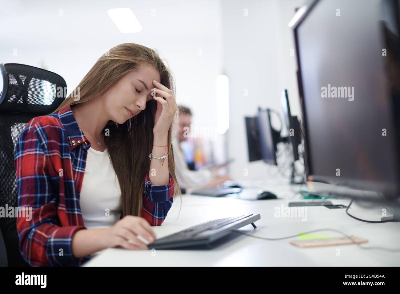 tired casual business woman taking a break while working on desktop ...