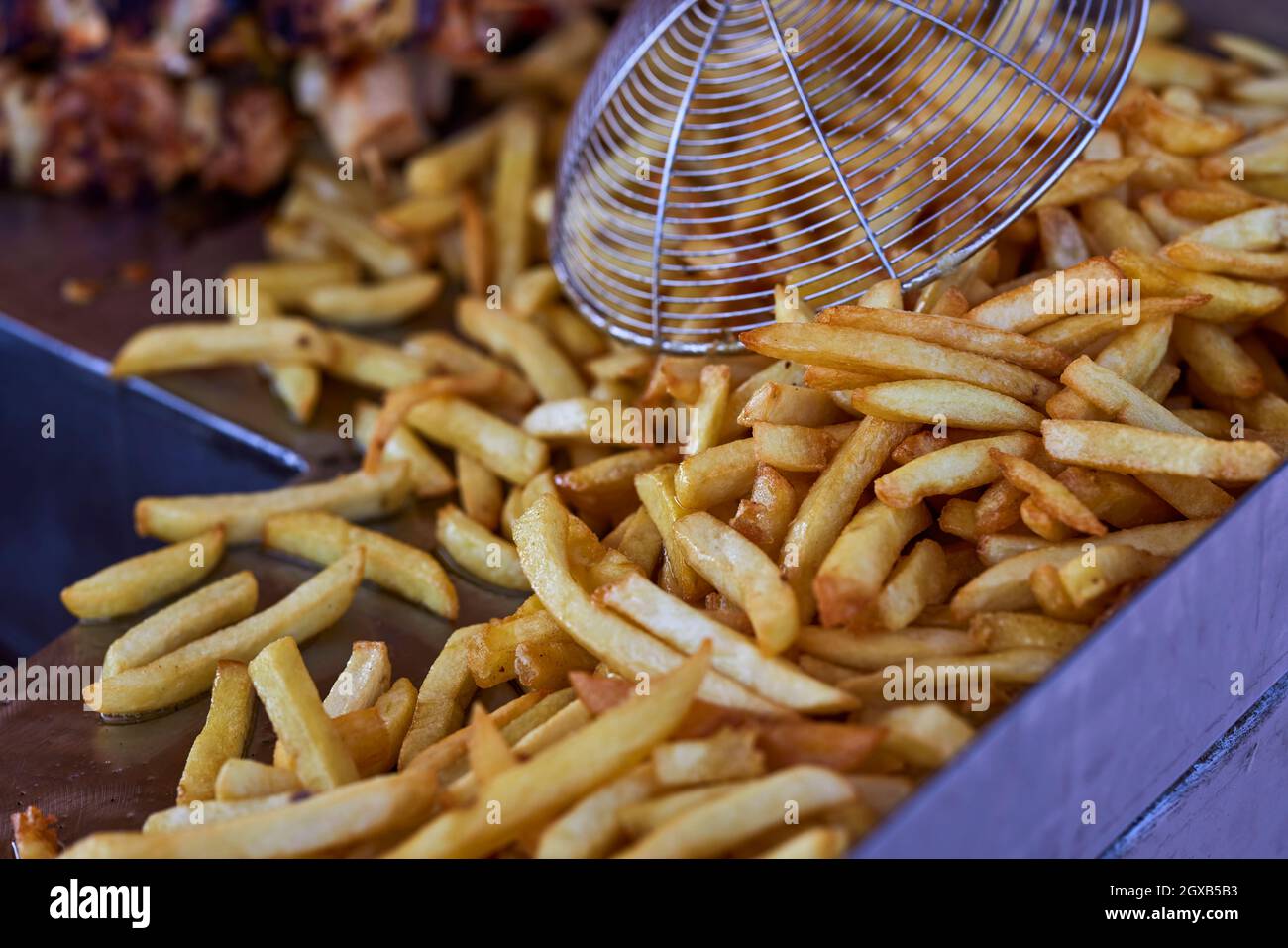 Deep fried French fries in fast food restaurant kitchen.Delicious snack ...