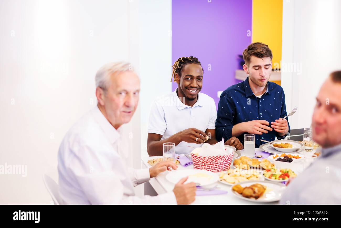 african american man enjoying iftar dinner together with modern ...