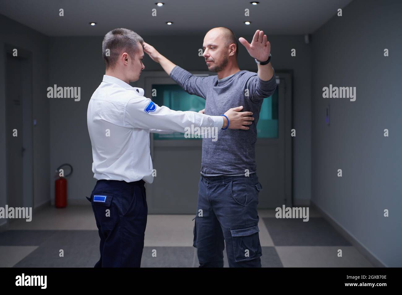 Security guard making body searching procedure on man for finding ...