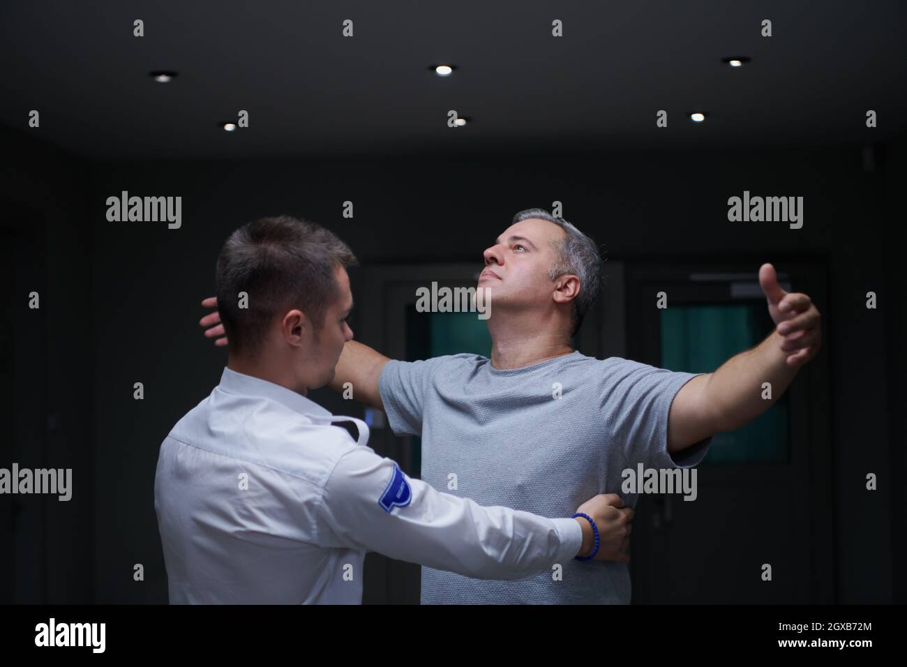 Security guard making body searching procedure on man for finding ...