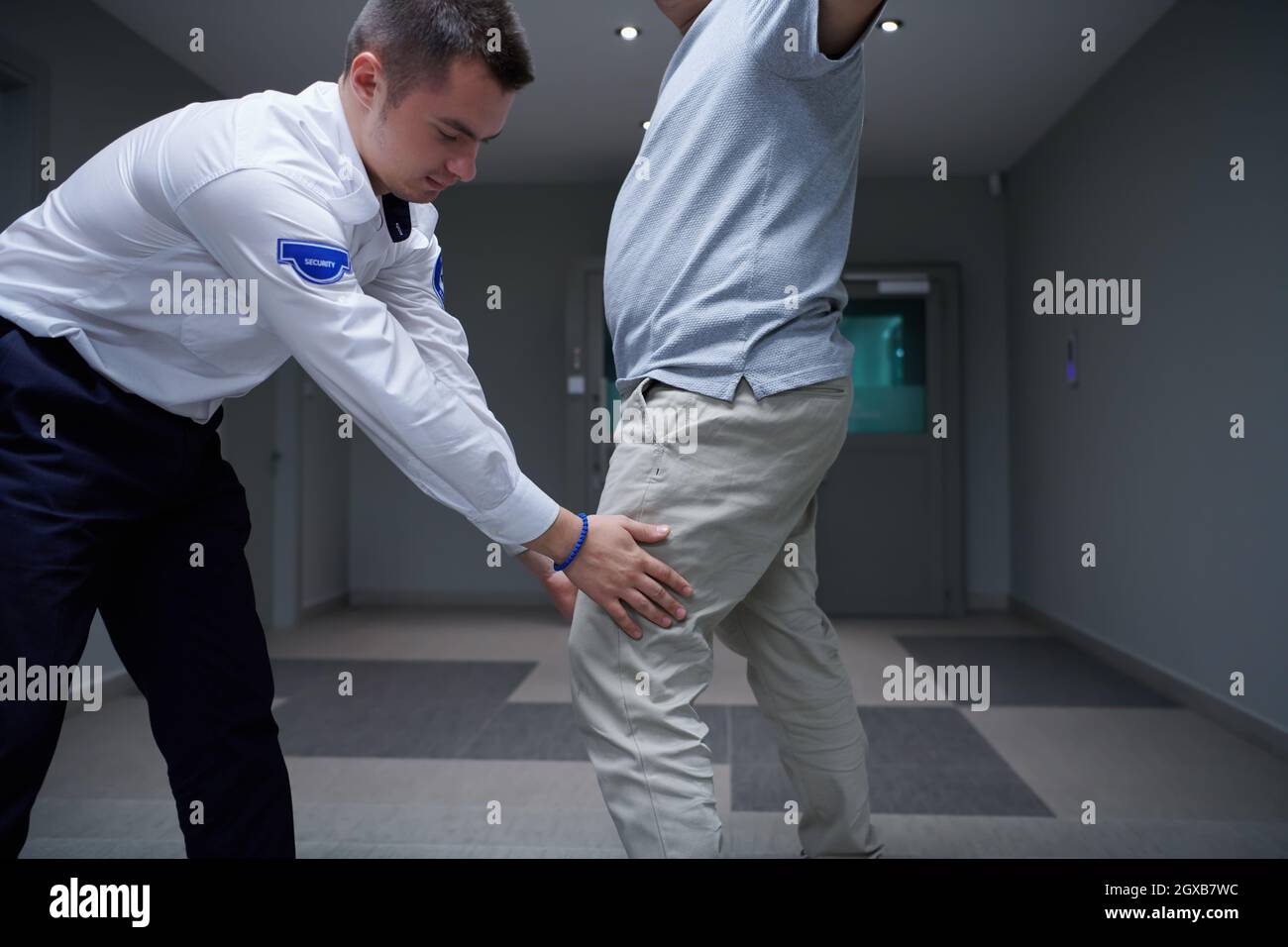 Security guard making body searching procedure on man for finding ...