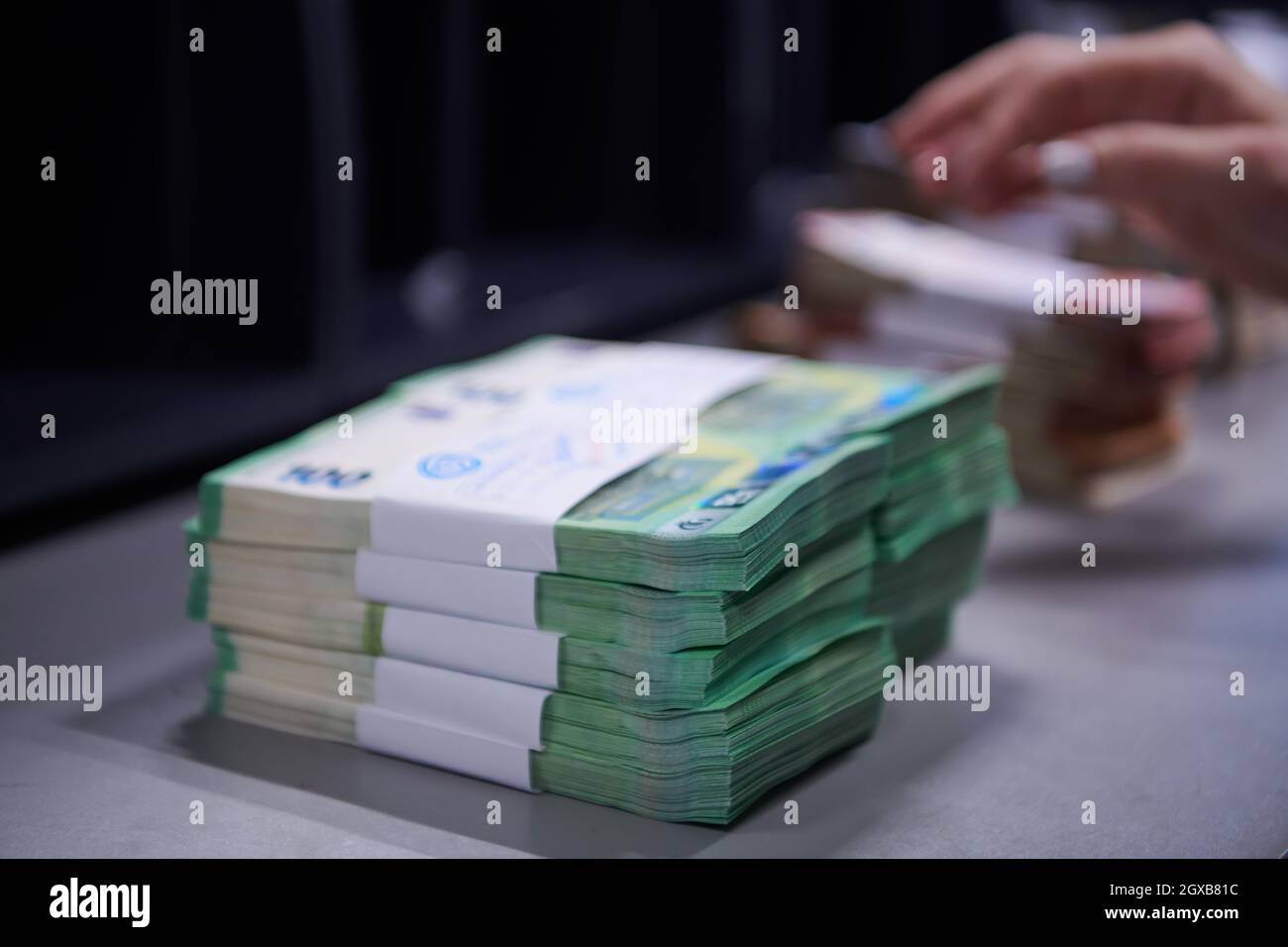 Bank employees using money counting machine while sorting and counting ...