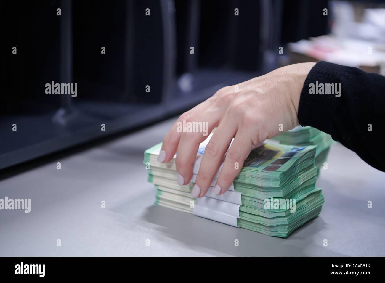 Bank employees using money counting machine while sorting and counting ...