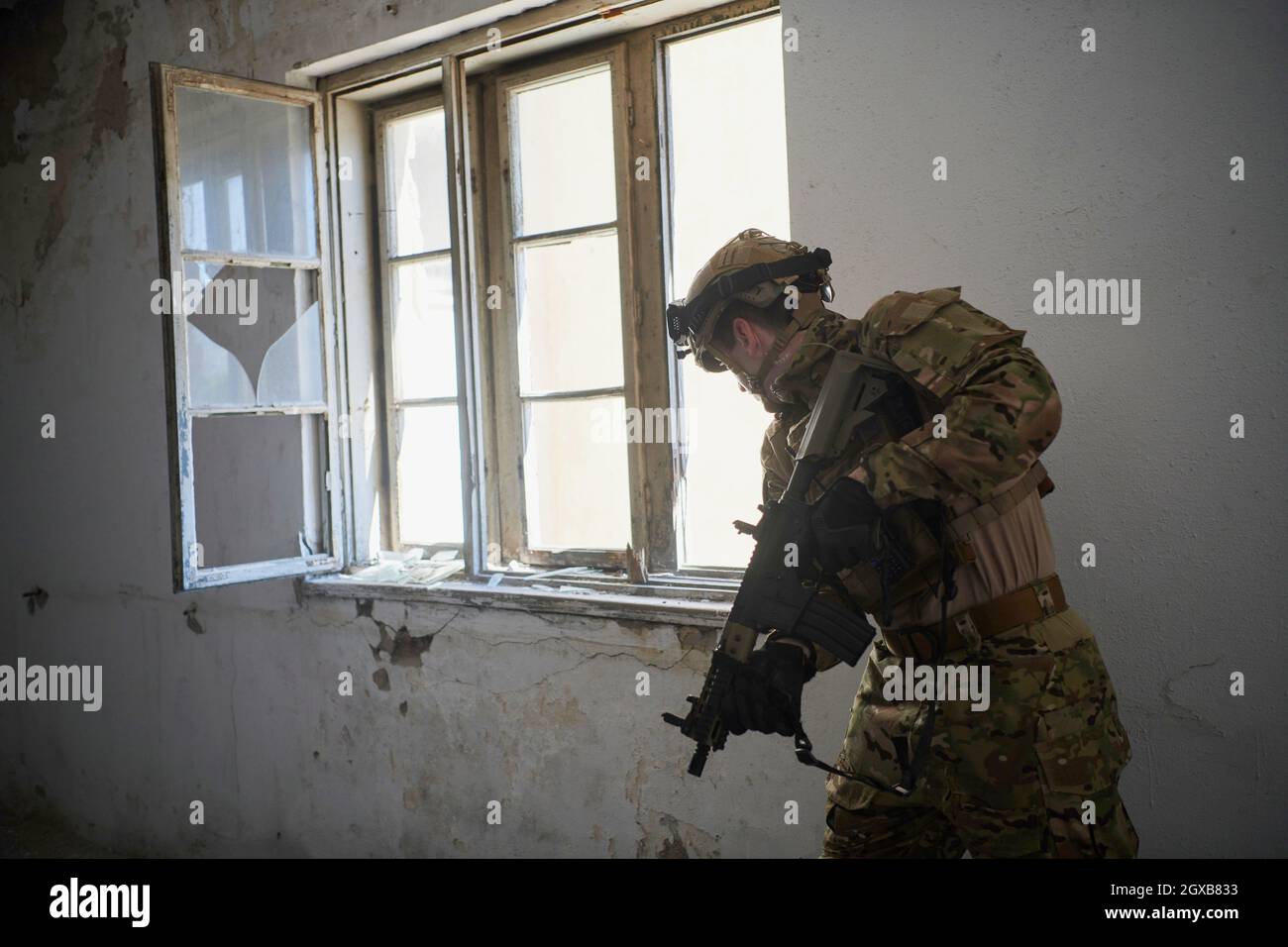 modern warfare soldier in action near window changing magazine and take ...