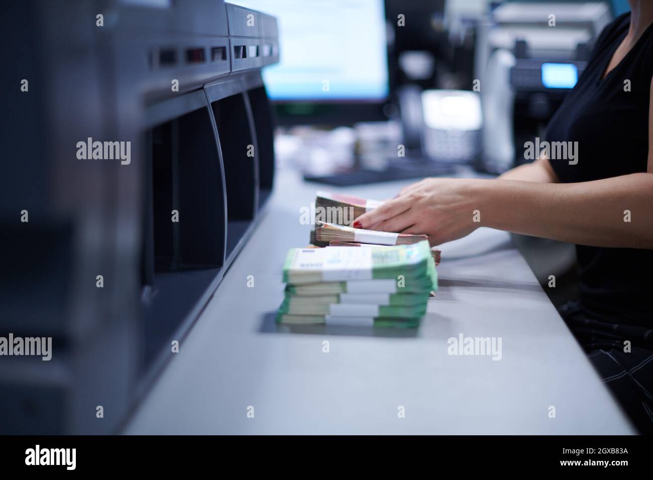 Bank employees using money counting machine while sorting and counting ...