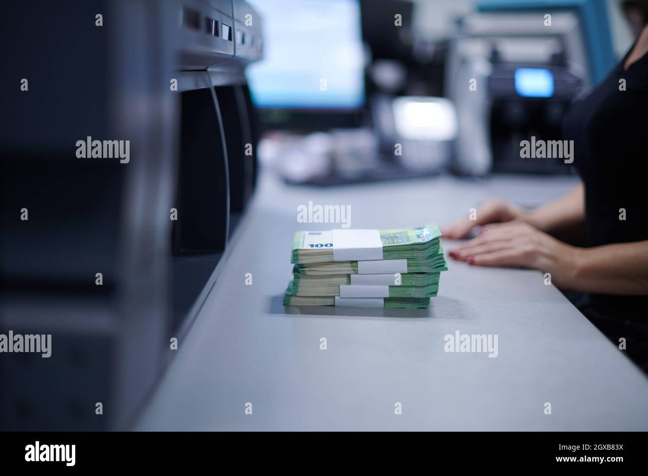 Bank employees using money counting machine while sorting and counting ...