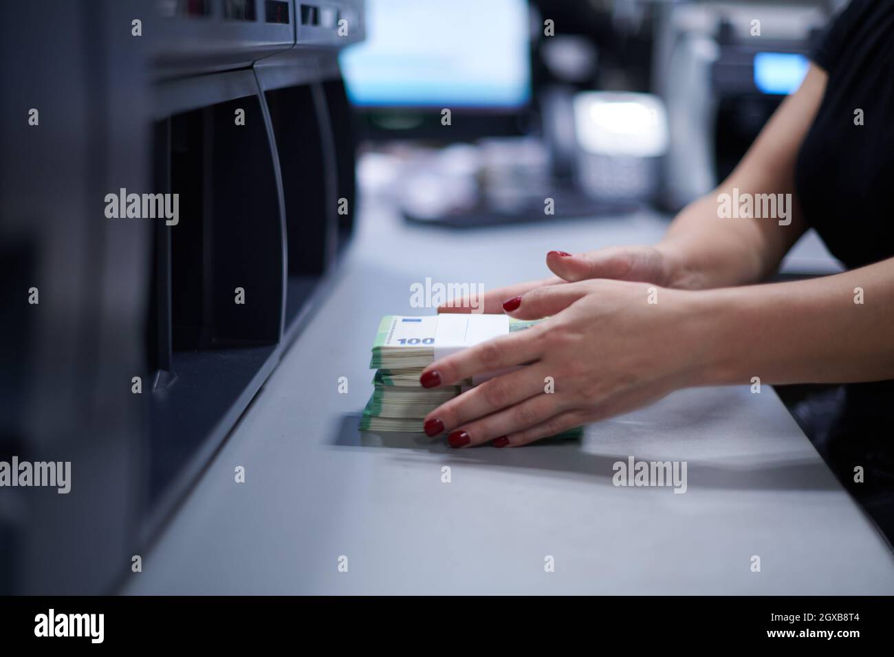 Bank employees using money counting machine while sorting and counting ...