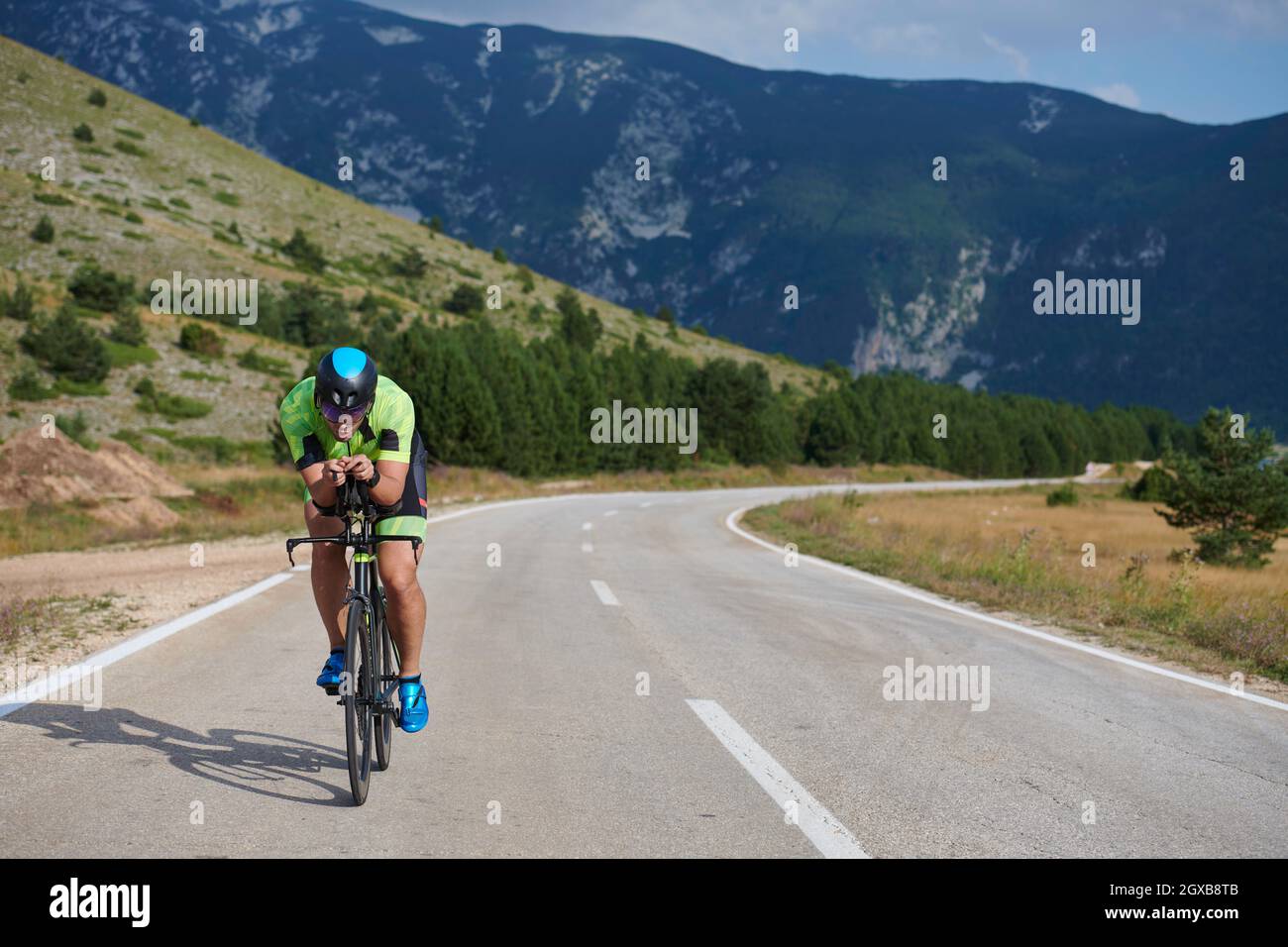 triathlon athlete riding professional racing bike at workout on curvy ...