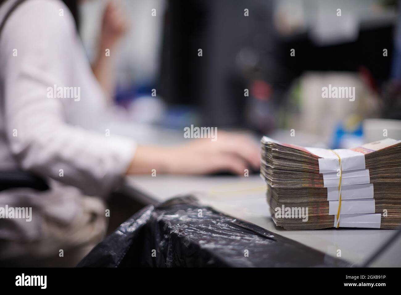 Bank employees using money counting machine while sorting and counting ...