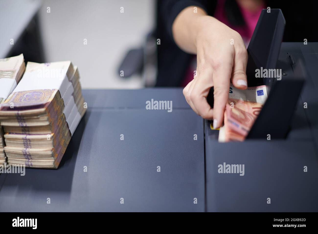 Bank employees using money counting machine while sorting and counting ...