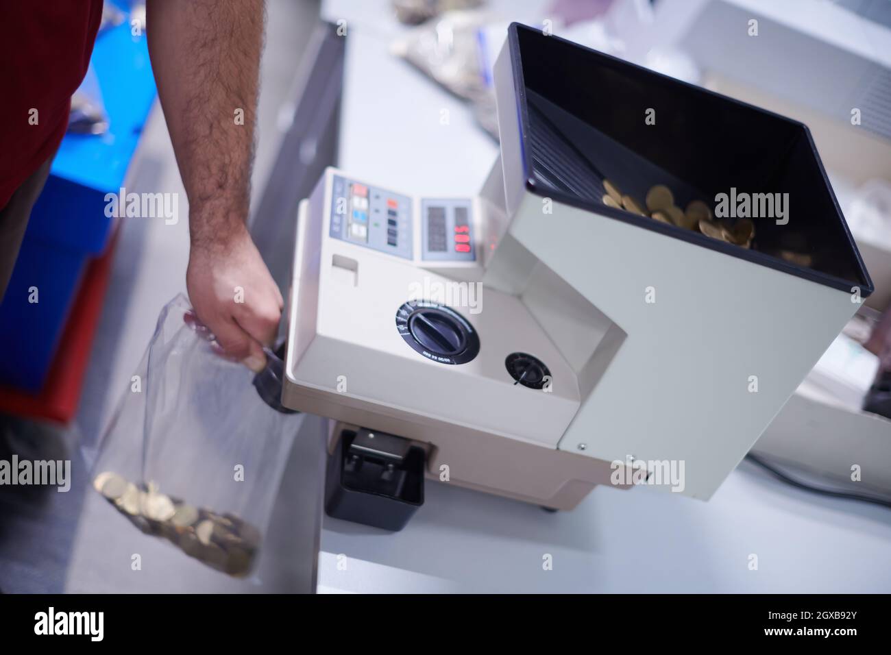 Bank employees using money counting machine while sorting and counting ...