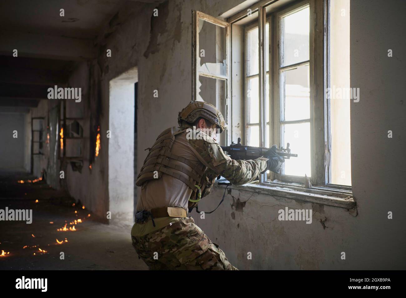 modern warfare soldier in action near window changing magazine and take ...