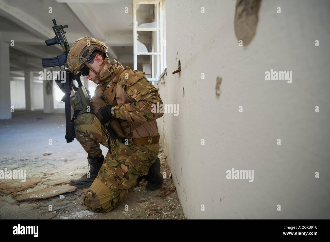 modern warfare soldier in action near window changing magazine and take ...