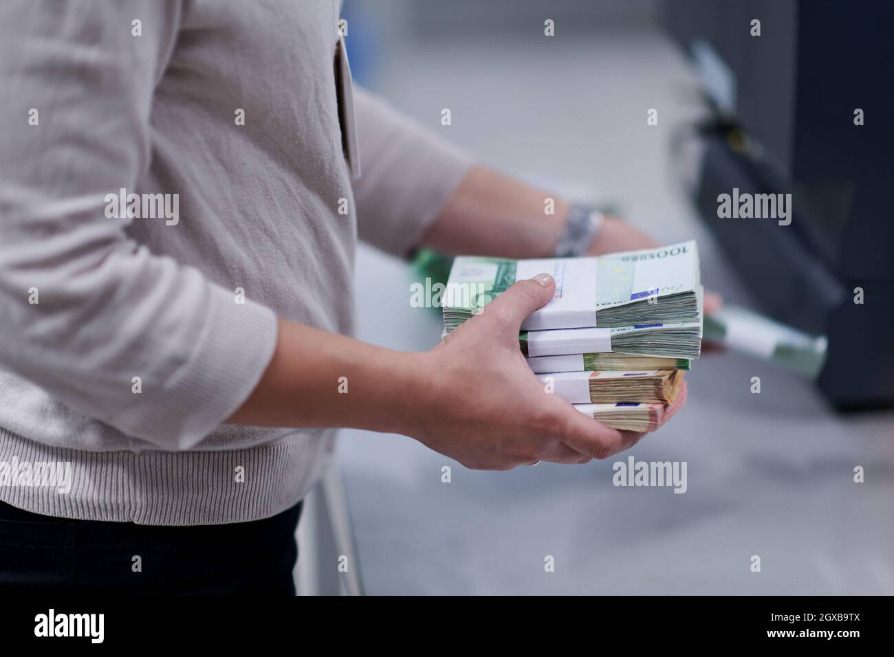 Bank employees using money counting machine while sorting and counting ...