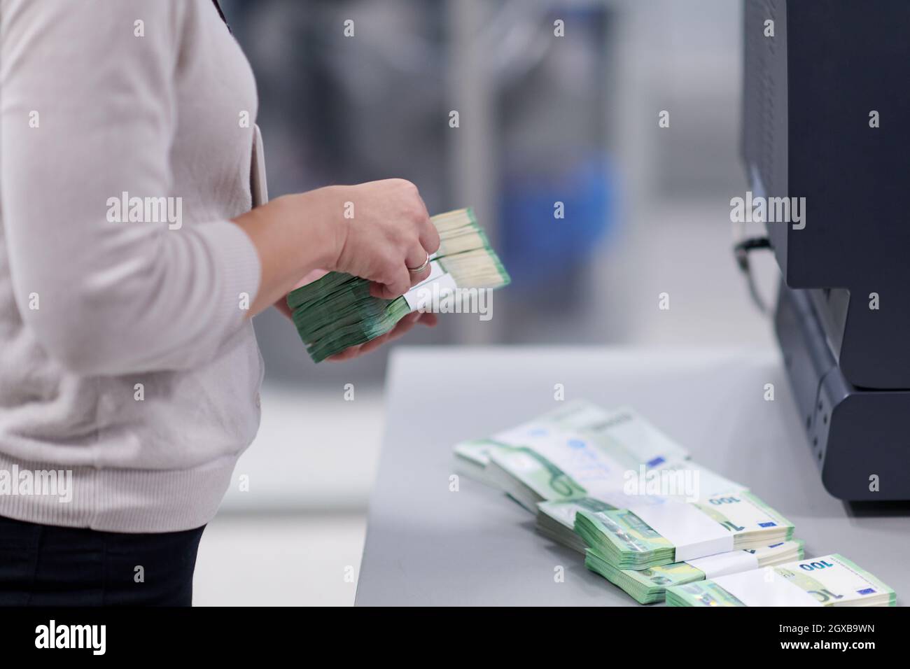 Bank employees using money counting machine while sorting and counting ...