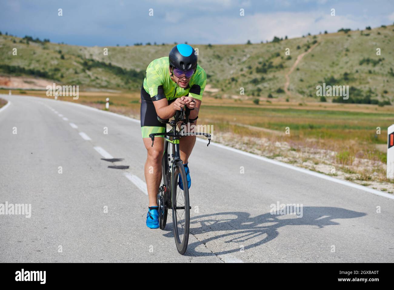 triathlon athlete riding professional racing bike at workout on curvy ...