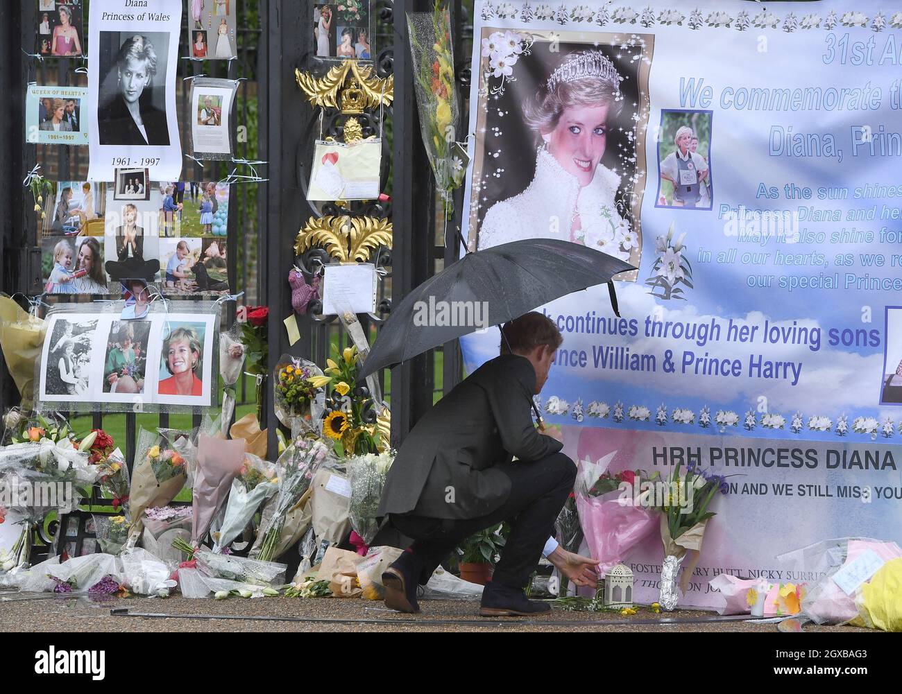 Prince Harry puts down a bouquet of flowers as he looks at tributes ...