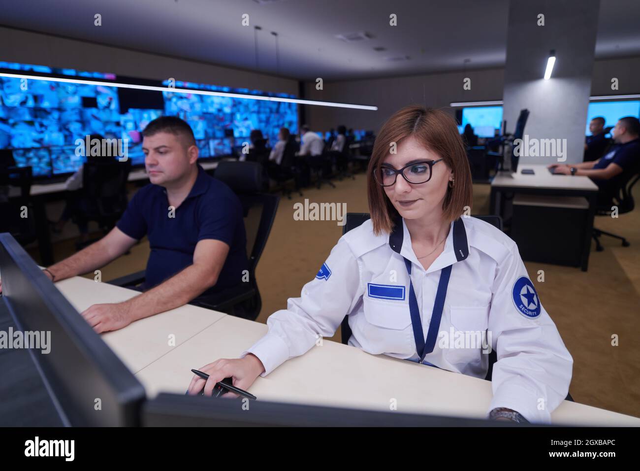 Female security operator working in a data system control room offices ...