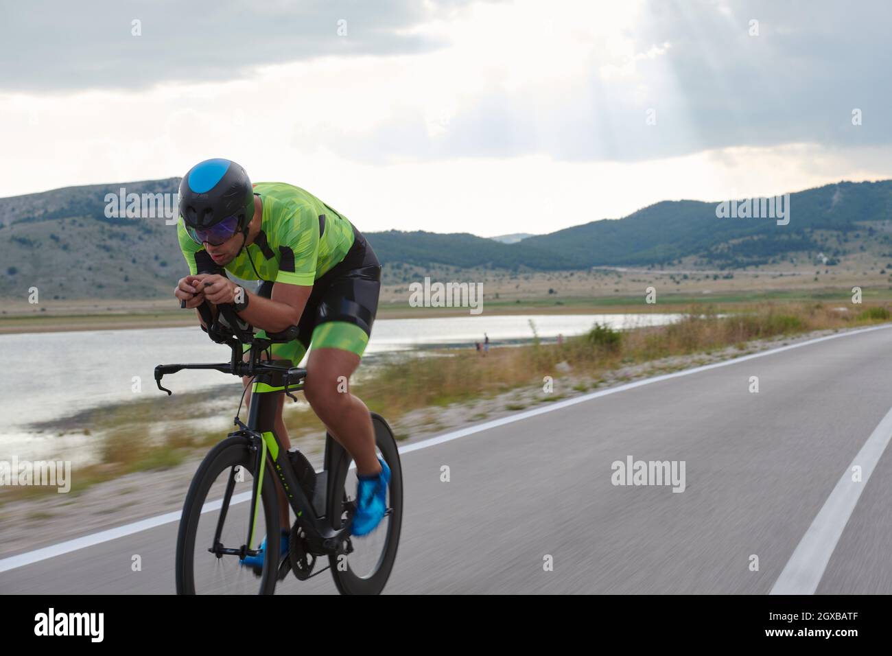 triathlon athlete riding professional racing bike at workout on curvy ...