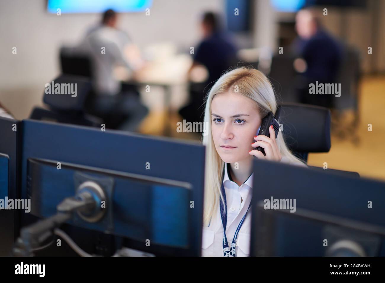 Female security guard operator talking on the phone while working at ...