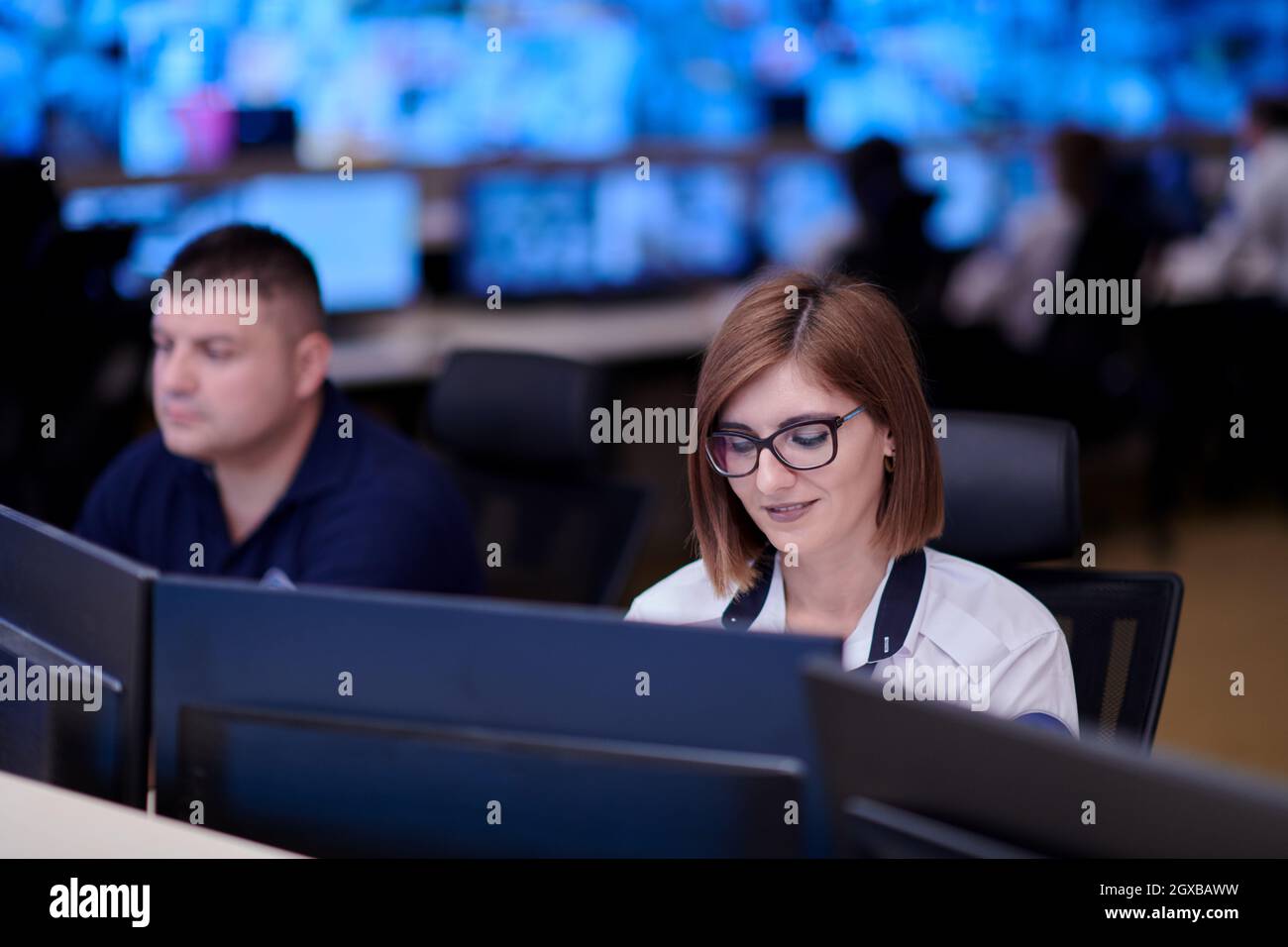 Female security operator working in a data system control room offices ...