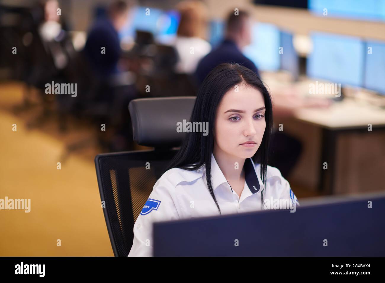 Female security operator working in a data system control room offices ...