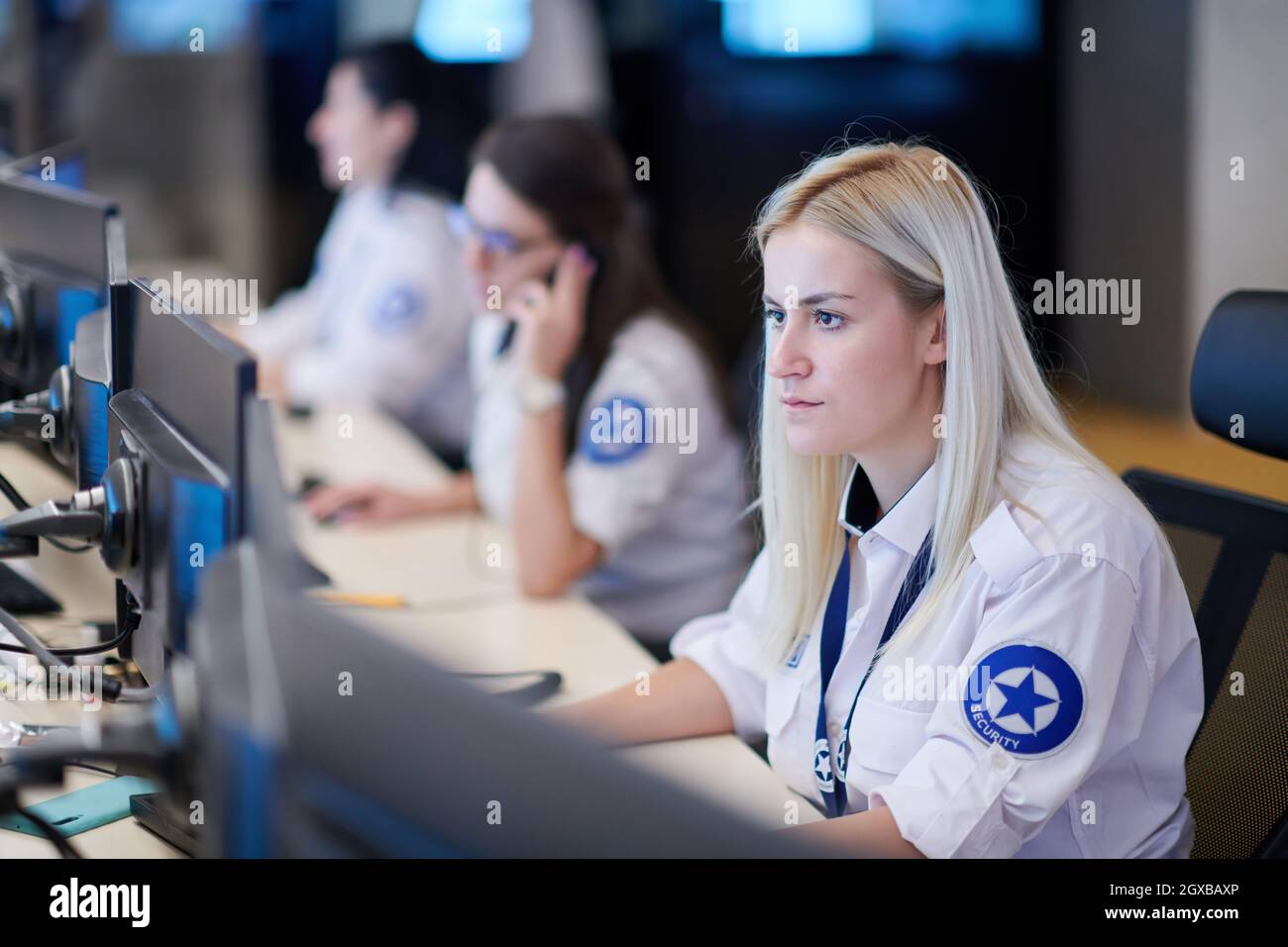 Female security operator working in a data system control room offices ...