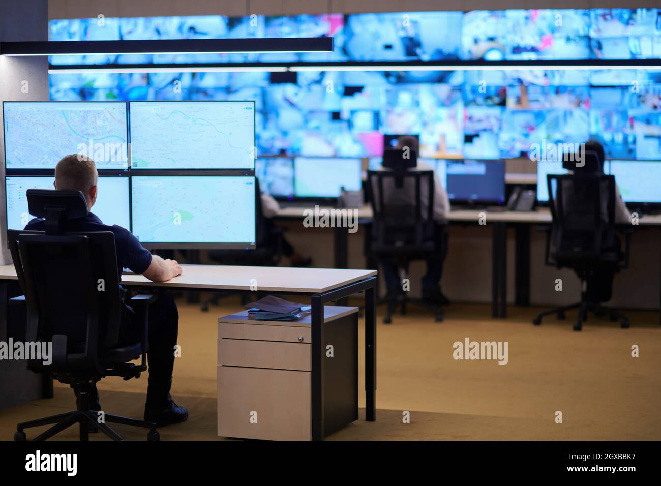 Male security operator working in a data system control room offices ...
