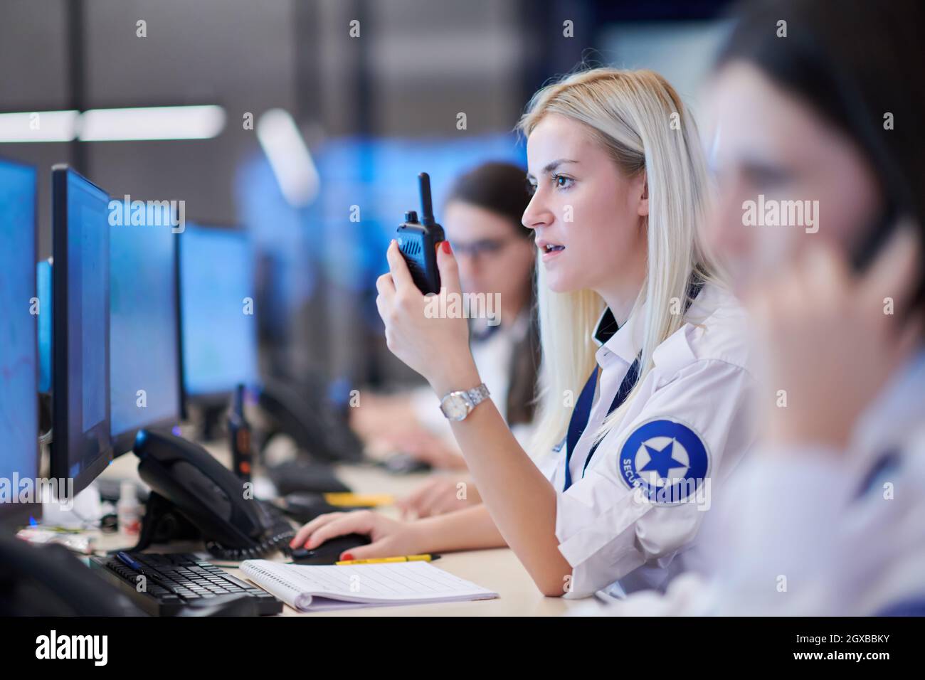 Female security operator working in a data system control room offices ...