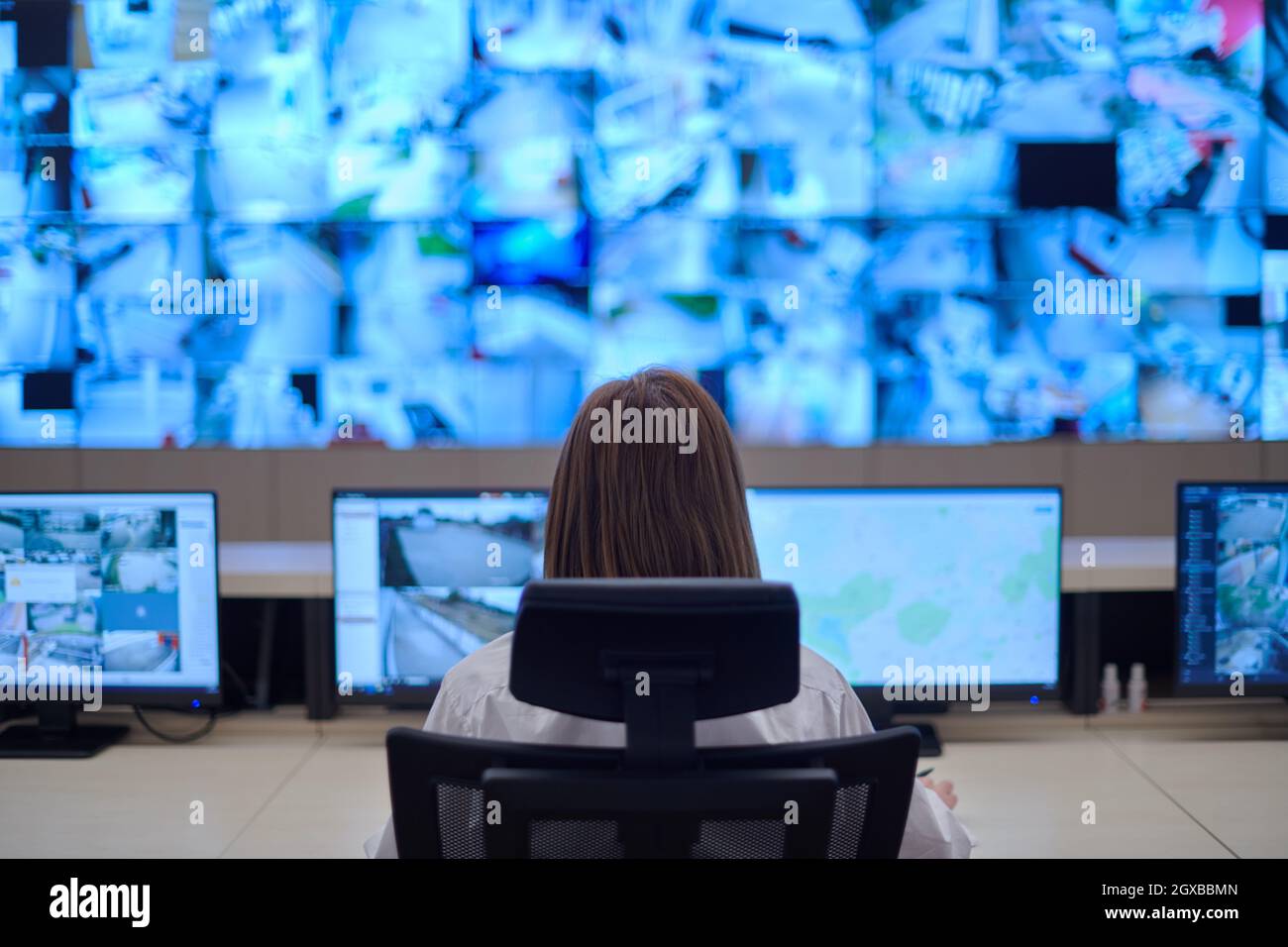 Female security operator working in a data system control room offices ...