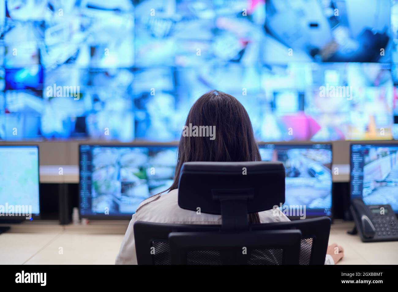 Female security operator working in a data system control room offices ...