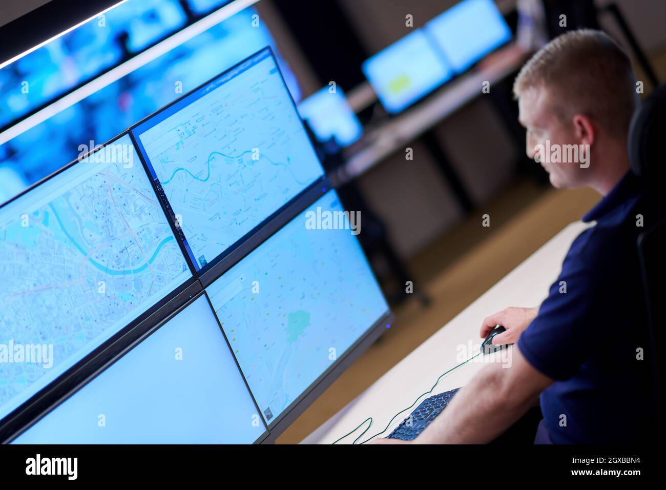 Male security operator working in a data system control room offices ...