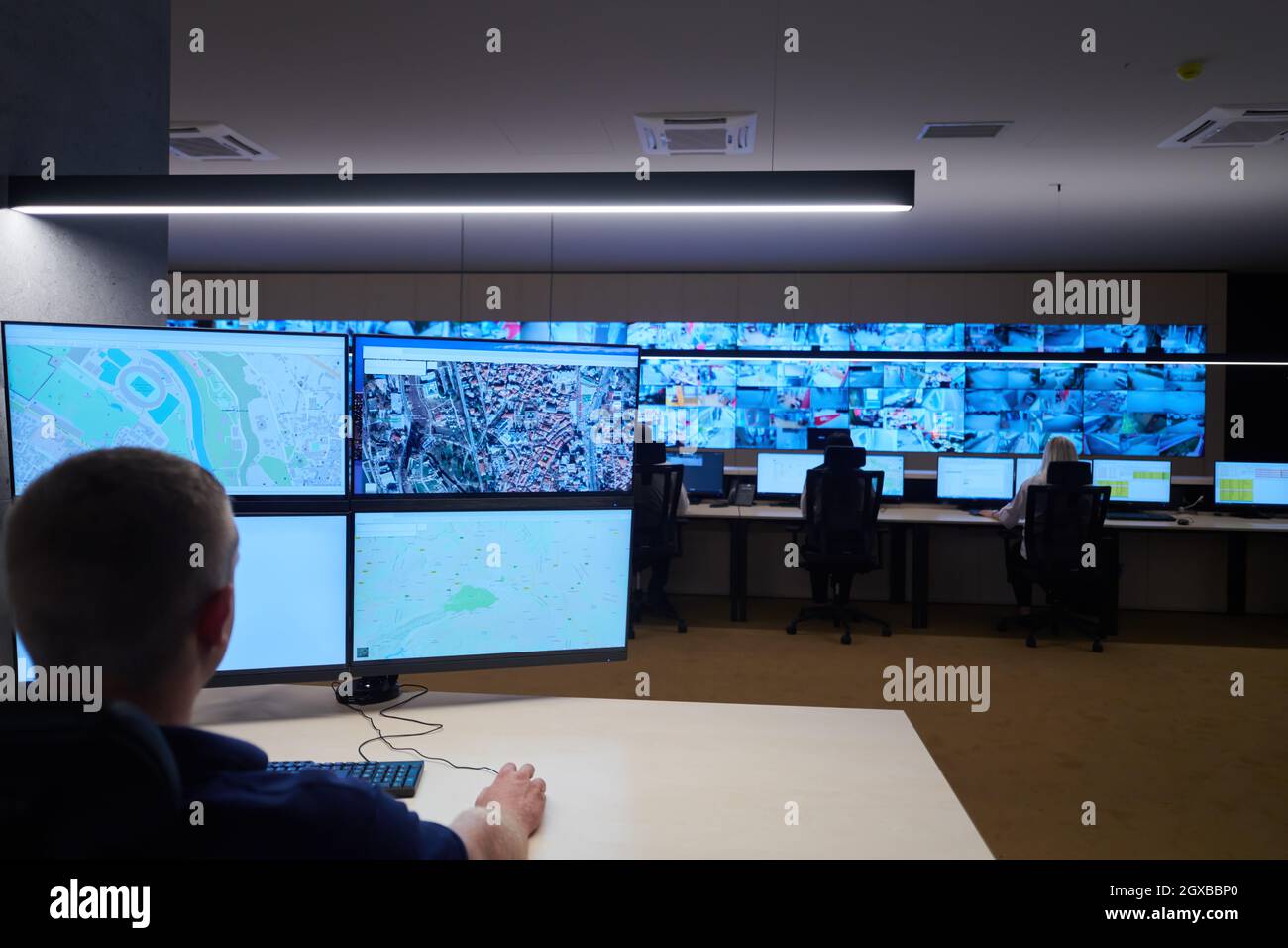 Male security operator working in a data system control room offices ...