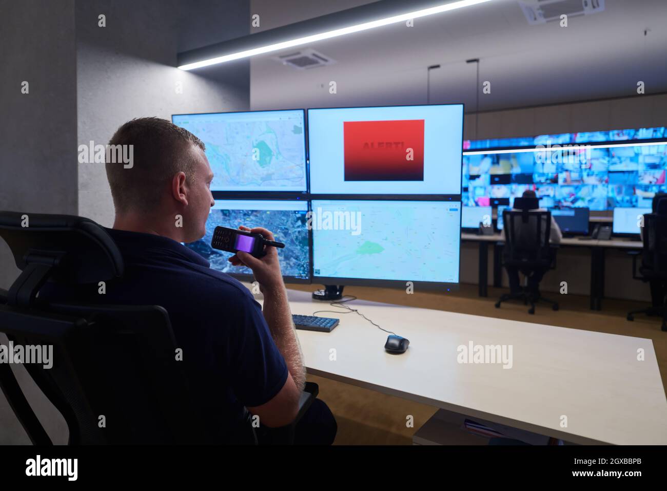 Male security operator working in a data system control room offices ...