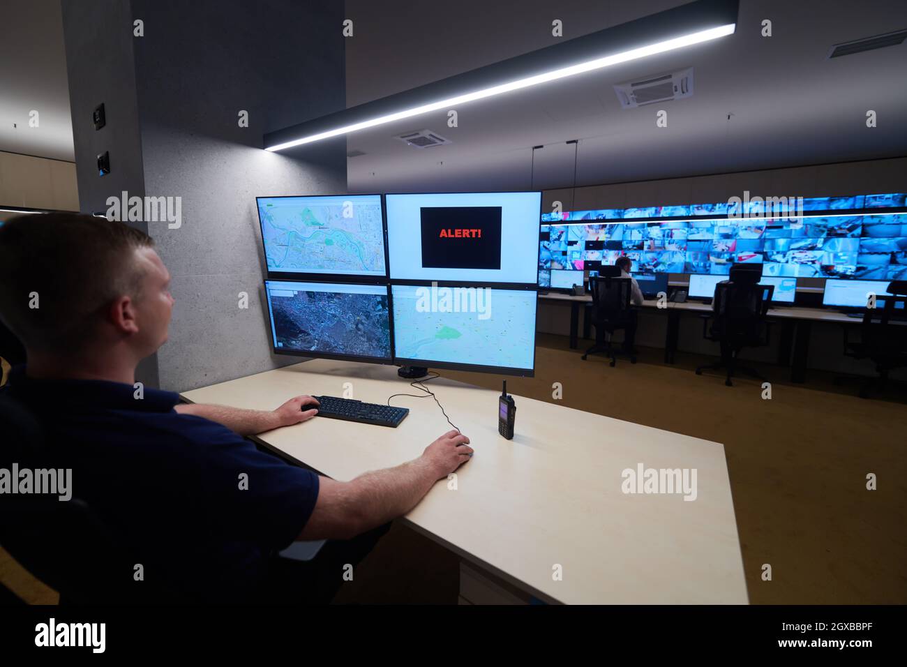 Male security operator working in a data system control room offices ...