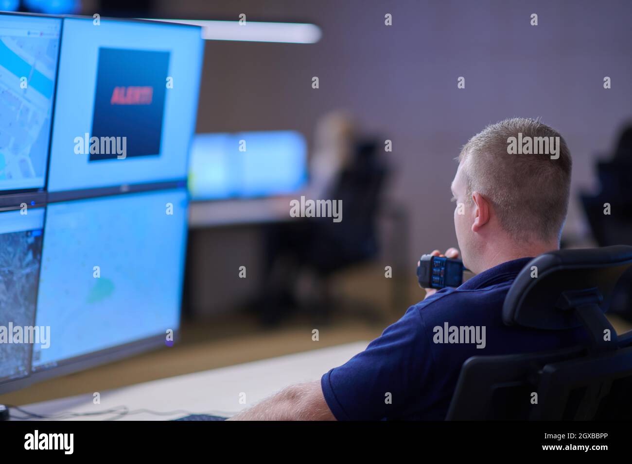 Male security operator working in a data system control room offices ...