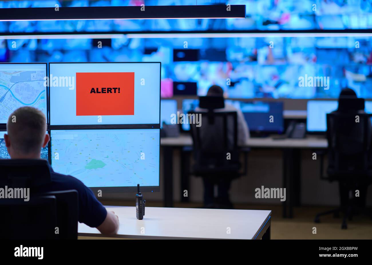 Male security operator working in a data system control room offices ...