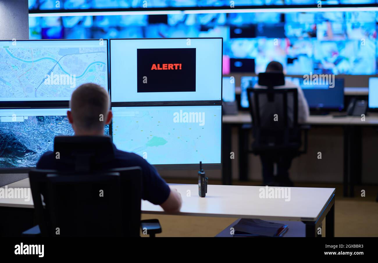 Male security operator working in a data system control room offices ...