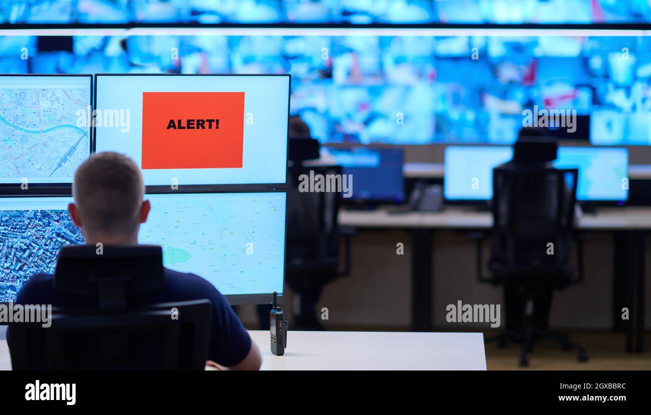 Male security operator working in a data system control room offices ...