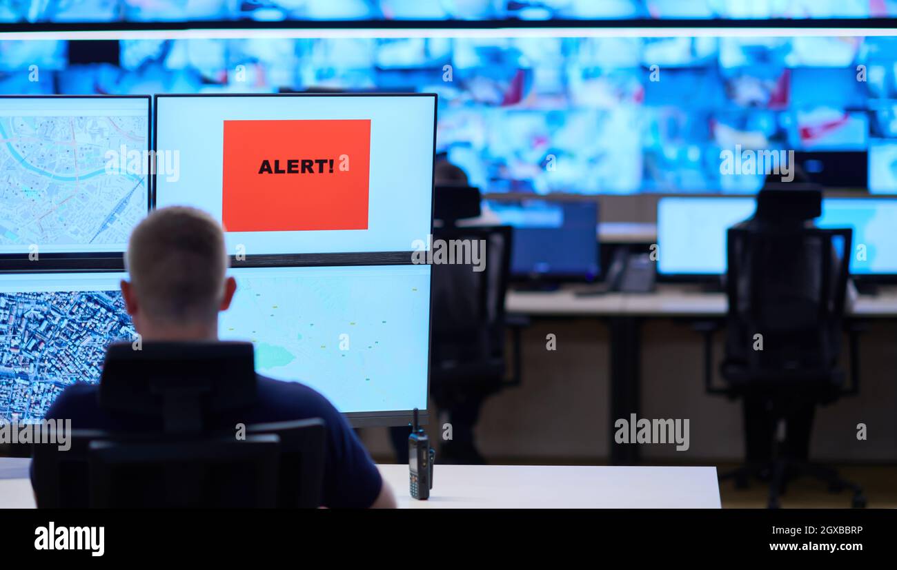 Male security operator working in a data system control room offices ...