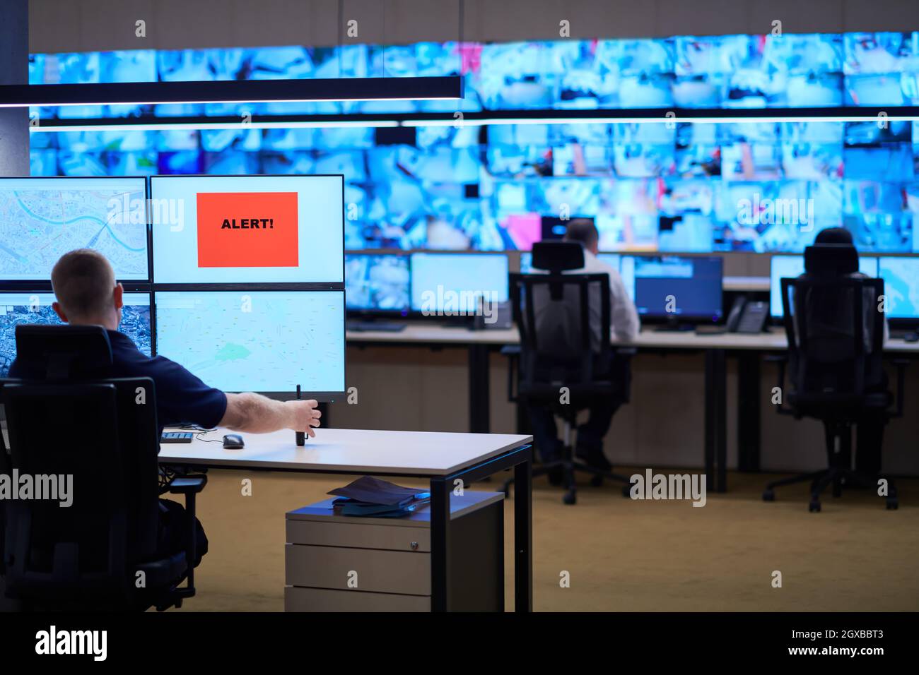Male security operator working in a data system control room offices ...