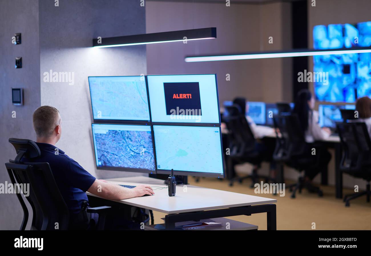 Male security operator working in a data system control room offices ...