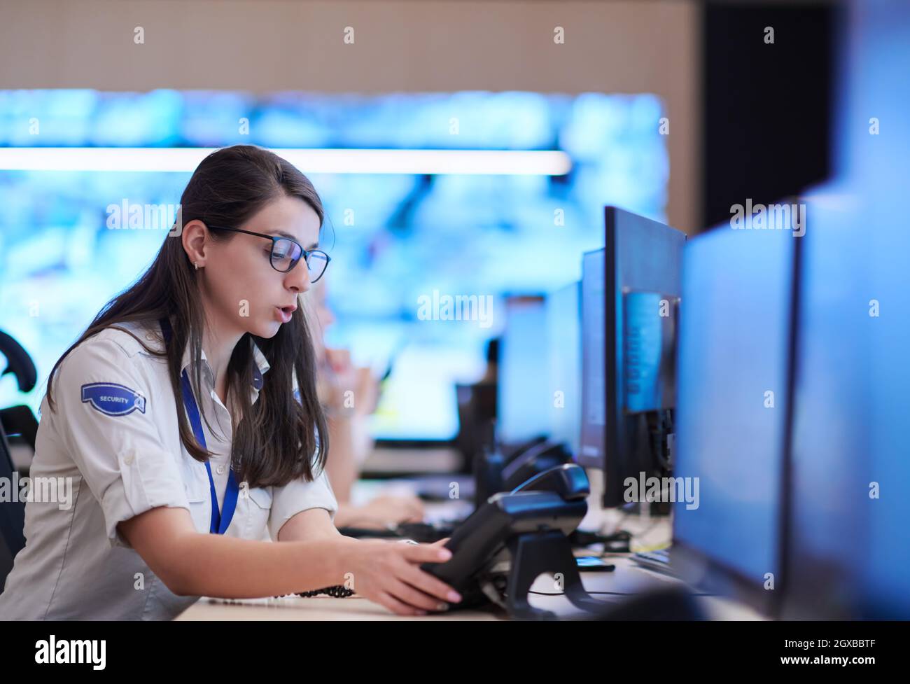 Female security operator working in a data system control room offices ...