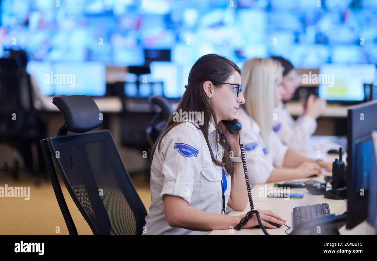 Female security guard operator talking on the phone while working at ...