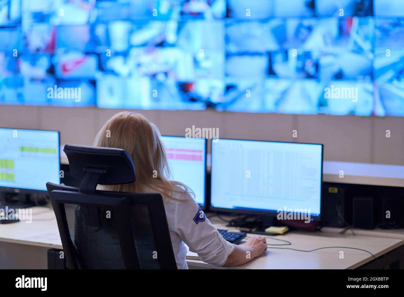 Female security operator working in a data system control room offices ...